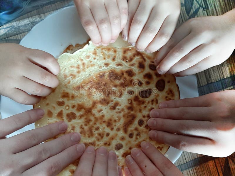 Children`s Hands Share a Pancake Lying on a Plate. Stock Image - Image ...