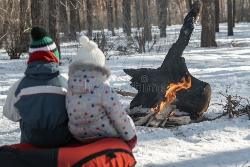 Children Sit and Look at Fire in the Winter Forest Back View. Winter ...