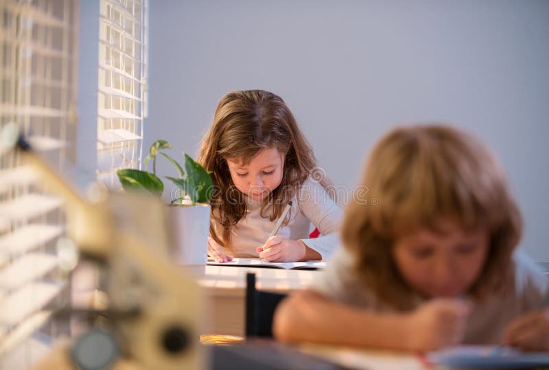 Children Sitting at Desk in School Classroom and Writing Test. Stock ...