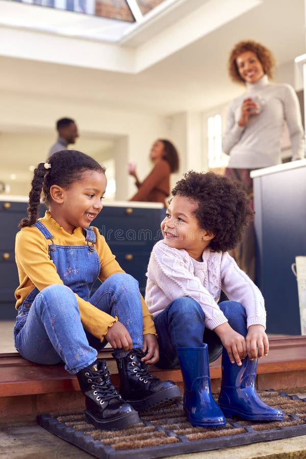 Children Sitting on Step at Home Putting on Boots before Going on ...