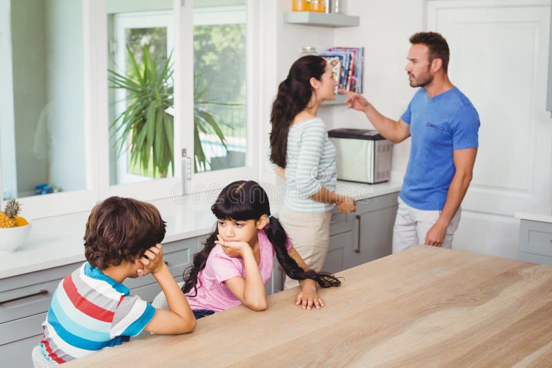 Children Sitting at Table with Parents Quarreling Stock Photo - Image ...