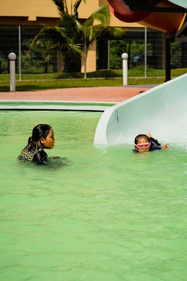 Children Sliding into Pool after Going Down Water Slide during Summer ...