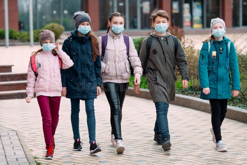 Children Students in Medical Masks Leave the School. Stock Photo ...