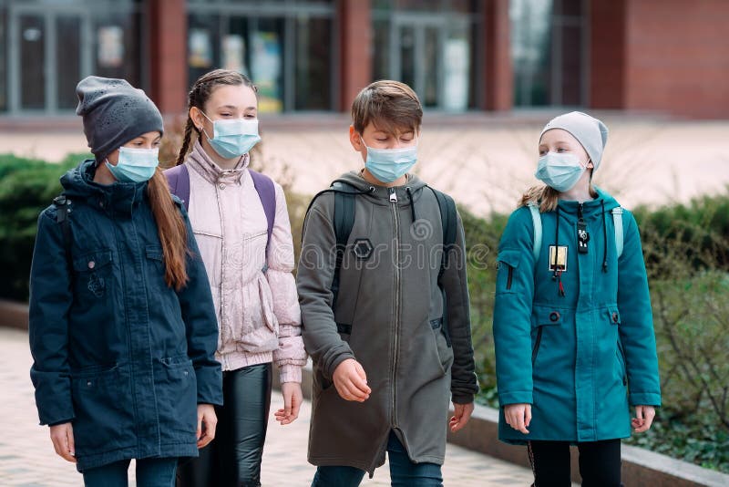 Children Students in Medical Masks Leave the School. Stock Photo ...