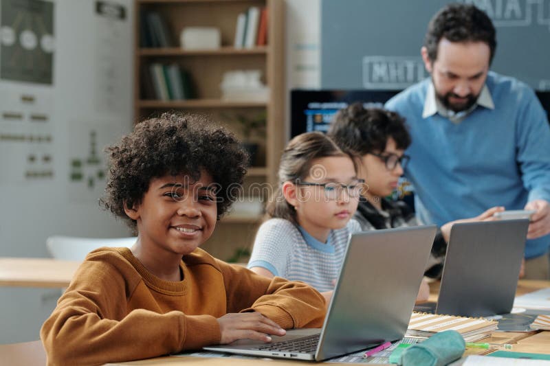 Children Studying Using Laptops with Teacher Assisting Stock Image ...