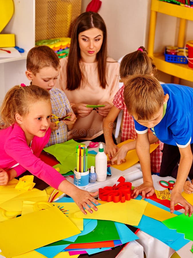 Children with Teacher are Making Something Out of Colored Paper. Stock ...