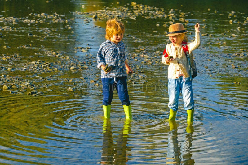 Children Throw Stones At The Stony River. Beautiful Children Throws A ...