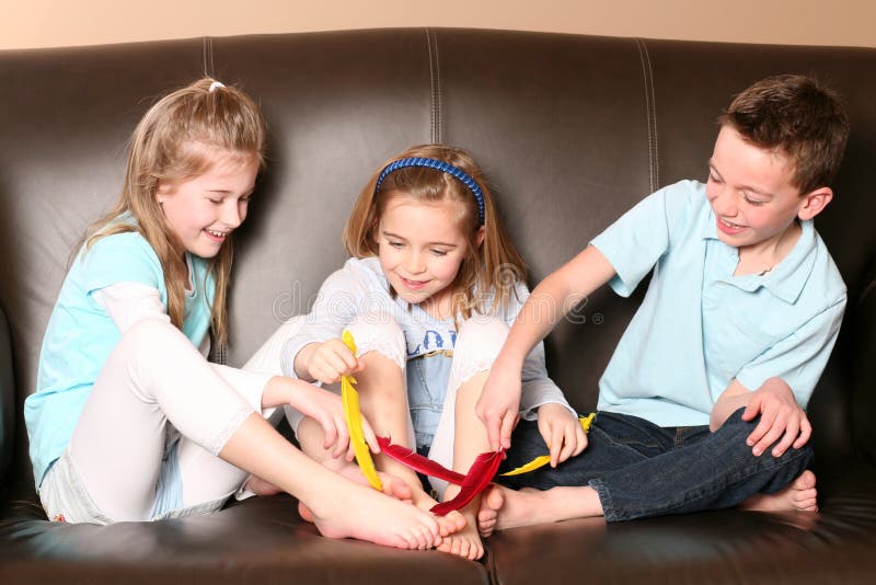 Children Tickling Feet With Feather Stock Photo - Image: 21165744