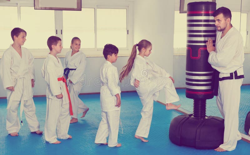 Children Training Karate Kicks on Punching Bag during Karate Class ...