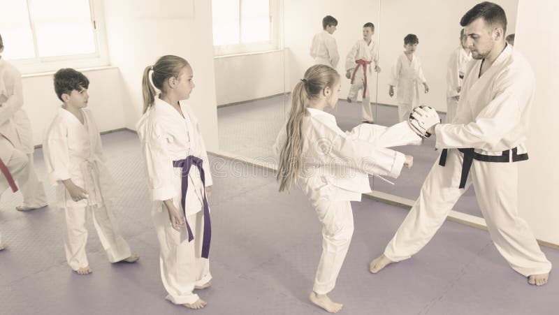 Children Training Karate Kicks on Punching Bag during Karate Class ...