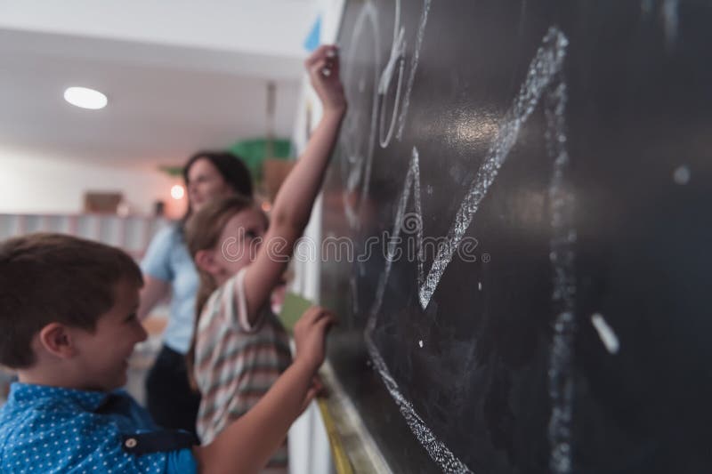 Children Write and Draw on the Blackboard in Elementary School while ...