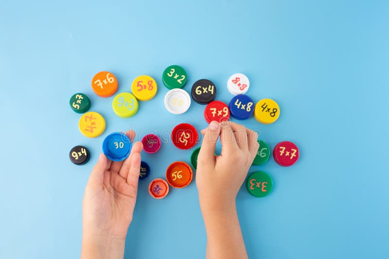 Childrens Hands Placing Colorful Caps with Multiplication Problems on ...