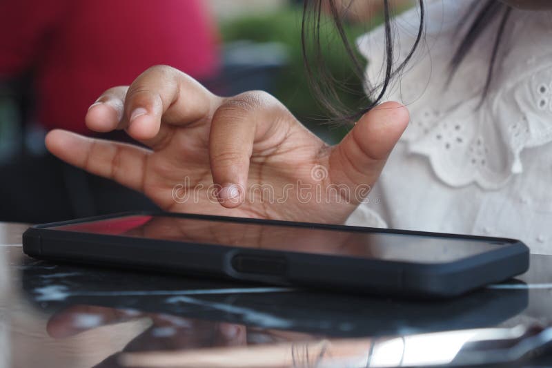 A Childs Hand Skillfully Using a Smartphone with a Focused and Engaging ...