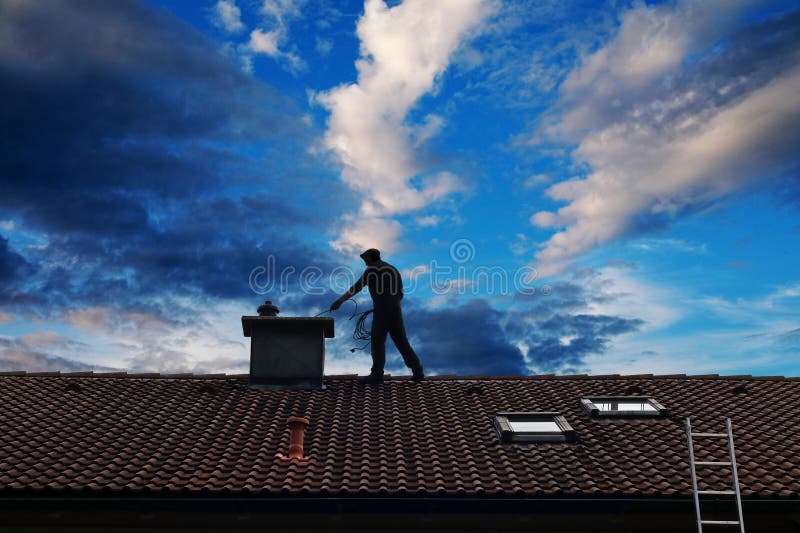 A Chimney Sweep Cleans the Chimney on the Roof of a House in Front of a ...