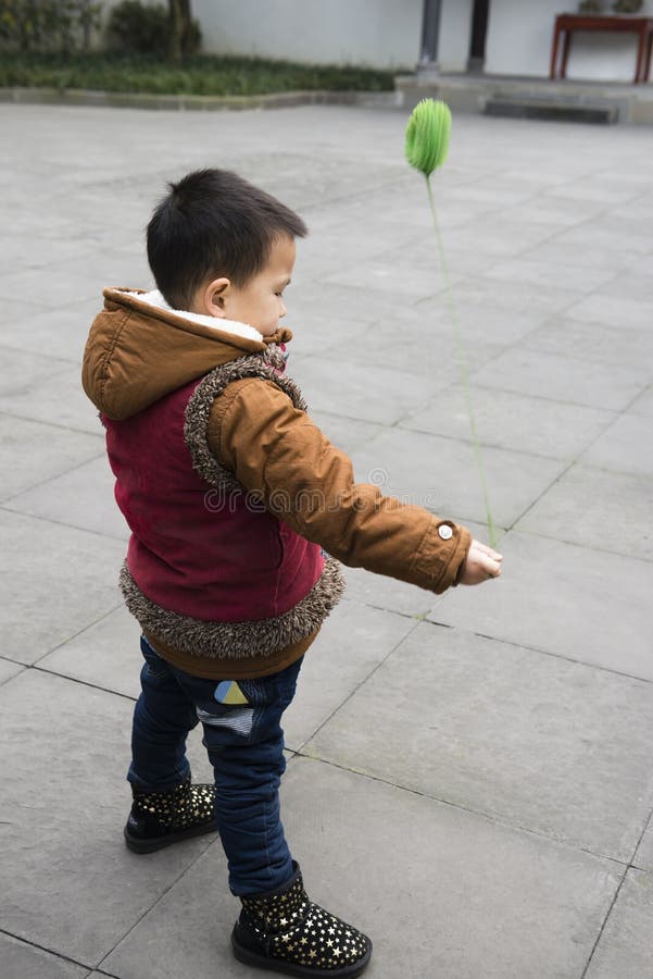 Chinese boy playing toy stock image. Image of pavement - 51529847