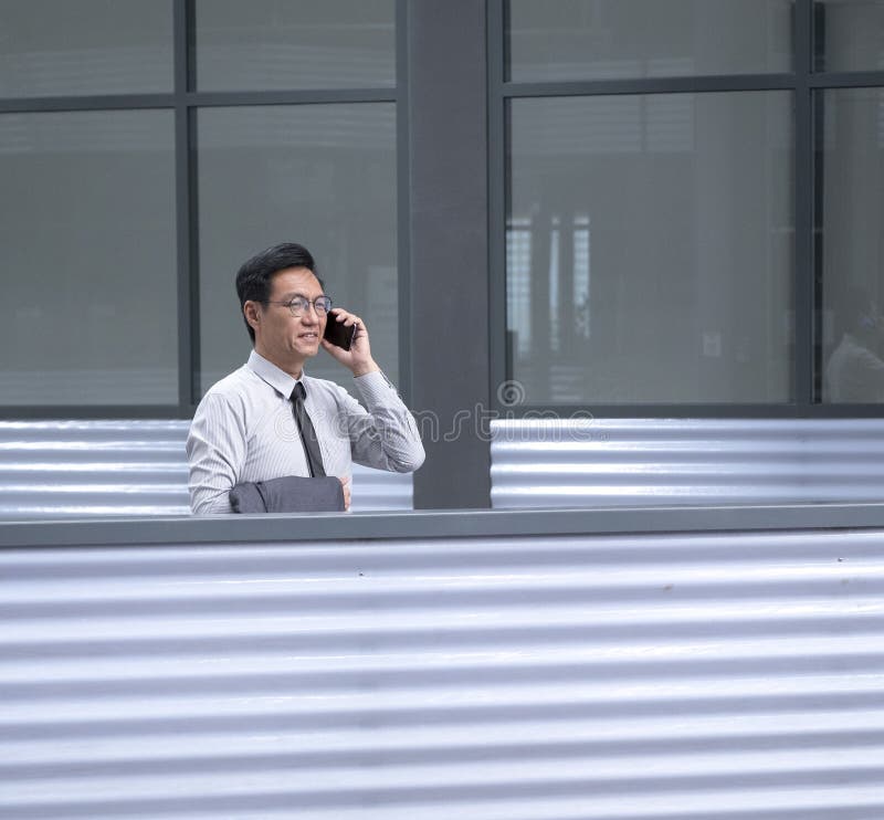 Chinese Businessman Standing and Talking on His Cellphone Stock Photo ...