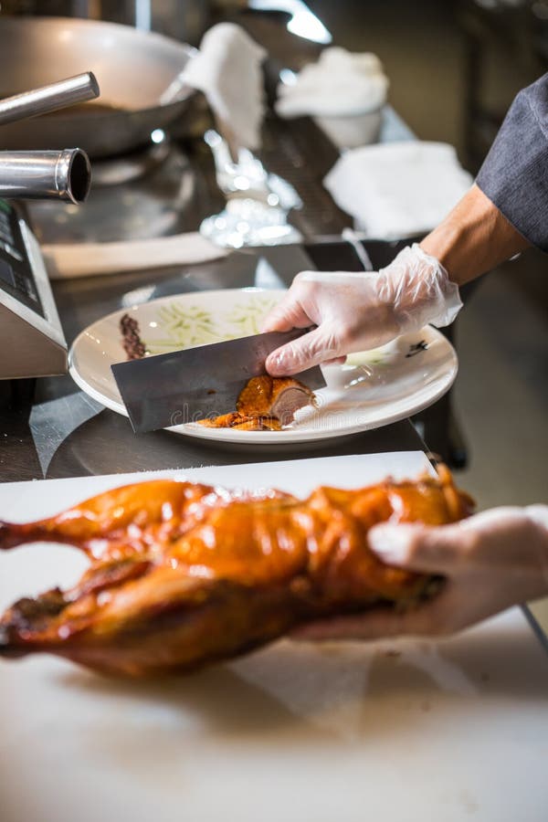 Chinese Chef Cooking Peking Roasted Duck at the Kitchen of Restaurant ...