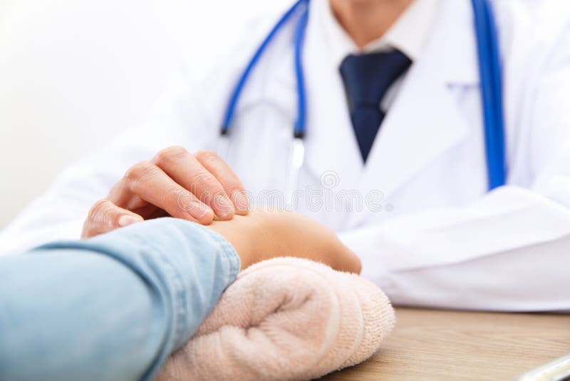 A Chinese Doctor in a White Lab Coat is Checking the Pulse of a Patient ...