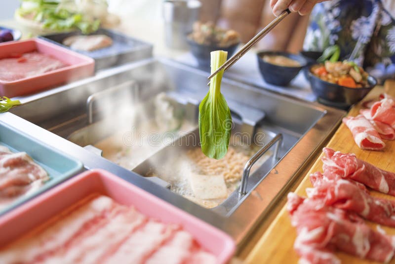Chinese Hot Pot Meal. Hands Taking Vegetable with Chopsticks Stock ...