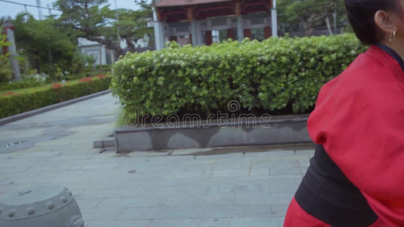 A Chinese Kids in a Red Costume Having Fun while Playing with the Rope ...