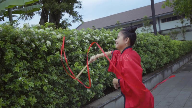 A Chinese Kids in a Red Costume Having Fun while Playing with the Rope ...
