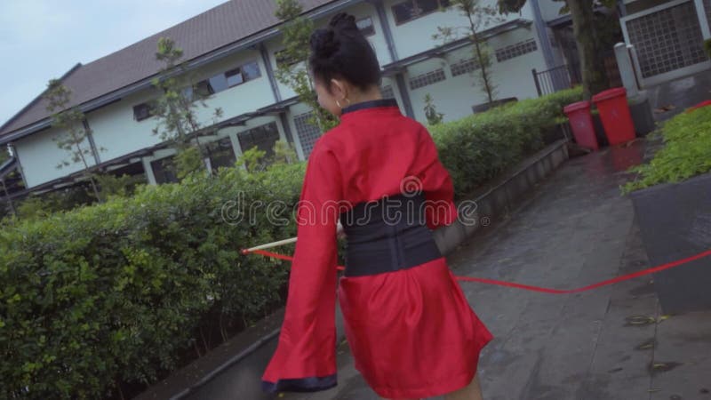 A Chinese Kids in a Red Costume Having Fun while Playing with the Rope ...