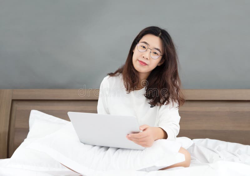 Chinese Lady Sitting on Bed and Using Computer Stock Photo - Image of ...
