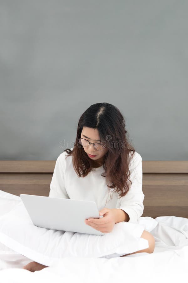 Chinese Lady Sitting on Bed Using Computer Stock Photo - Image of home ...