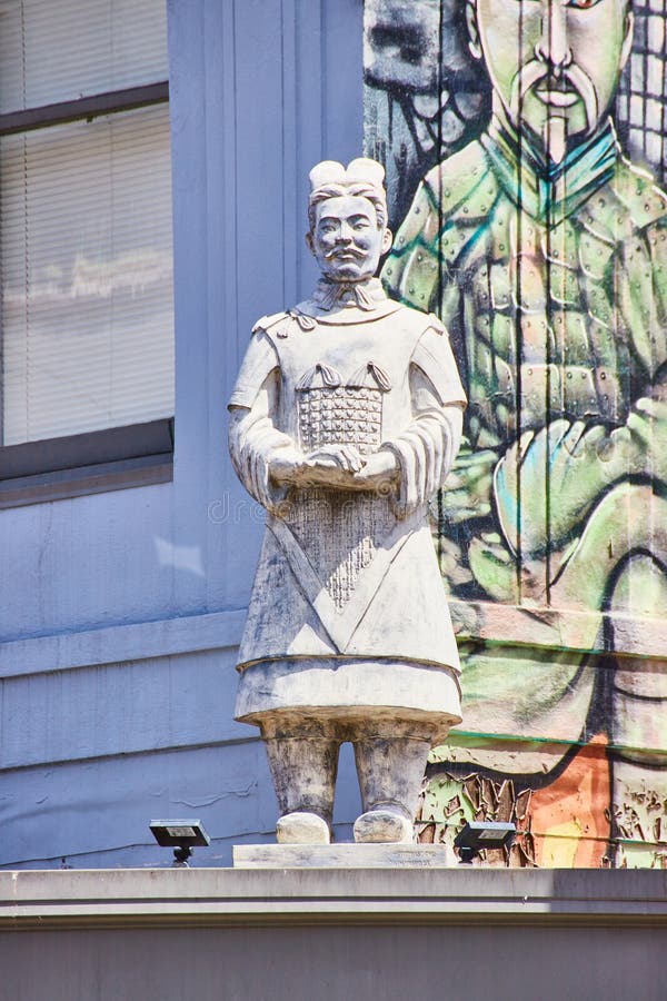 Chinese Man Statue on Corner of Building Rooftop with Wall Mural Behind ...