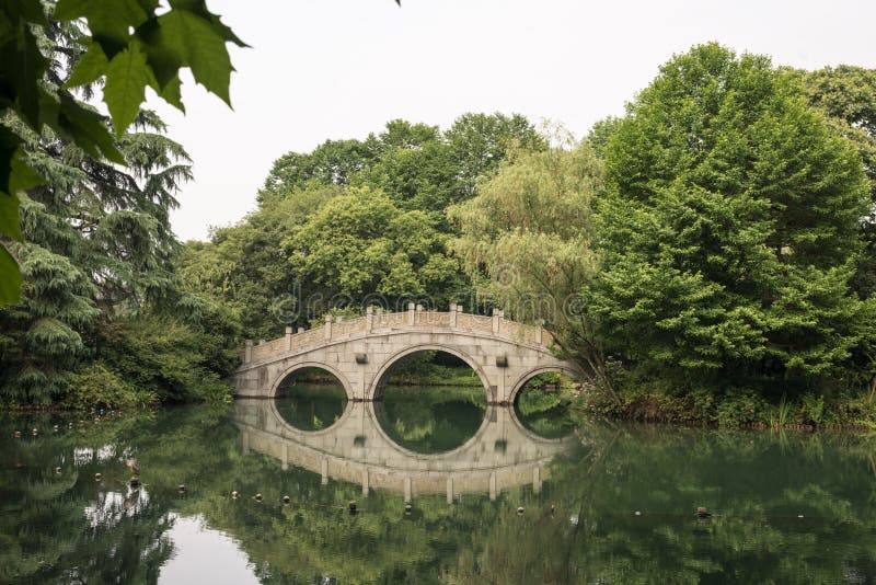 Chinese Stone Bridge with Symetrical Reflection in Lake Stock Image ...