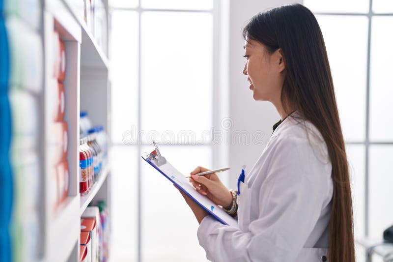 Chinese Woman Pharmacist Writing on Document at Pharmacy Stock Image ...