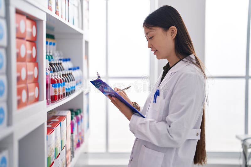 Chinese Woman Pharmacist Writing on Document at Pharmacy Stock Image ...