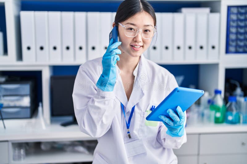 Chinese Woman Scientist Using Touchpad Talking on Smartphone at ...