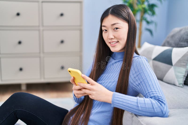Chinese Woman Using Smartphone Sitting on Floor at Home Stock Photo ...