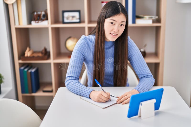 Chinese Woman Writing on Notebook Sitting on Table at Home Stock Photo ...