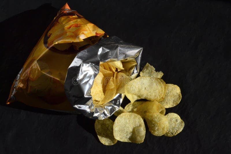 Chips from a Packet are Scattered on the Black Table Stock Image ...