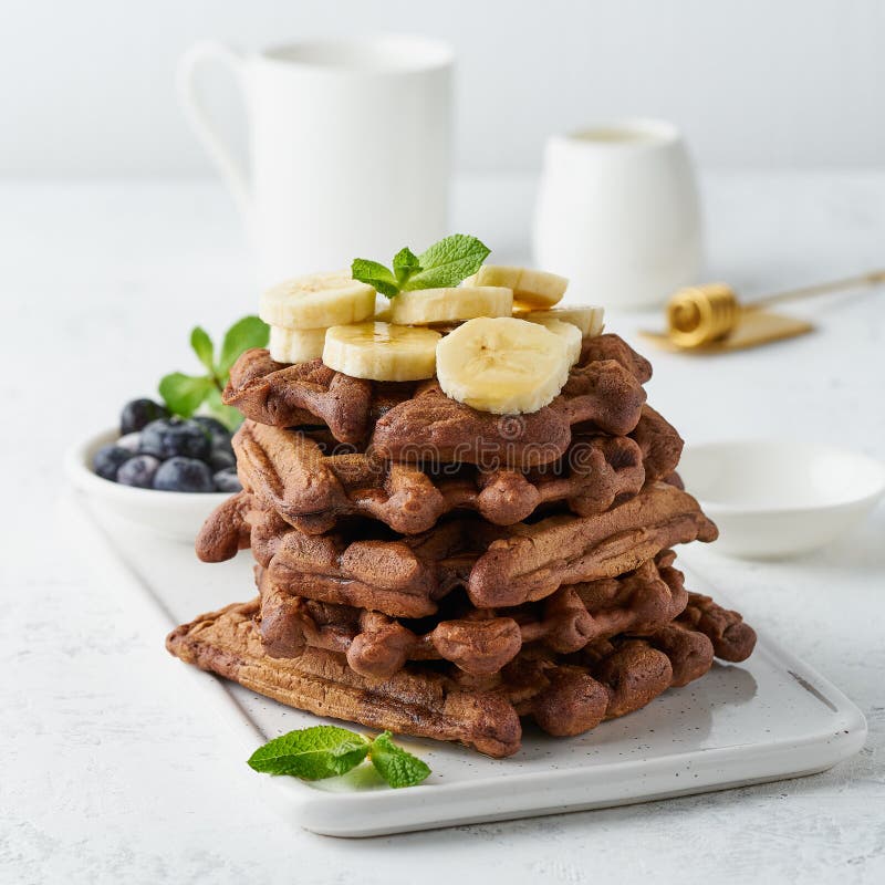 Chocolate Banana Waffles with Maple Syrup on White Table, Close Up ...