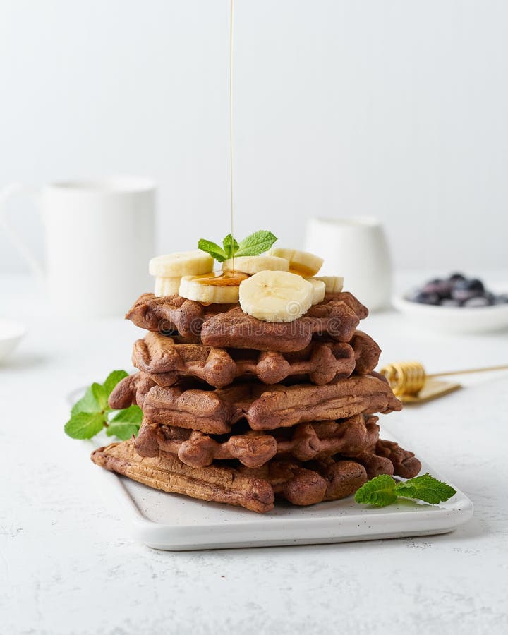 Chocolate Banana Waffles with Maple Syrup on White Table, Side View ...