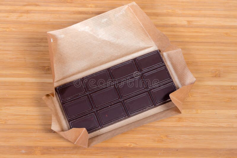 Chocolate Bar in Open Paper Wrapper on the Wooden Surface Stock Image ...