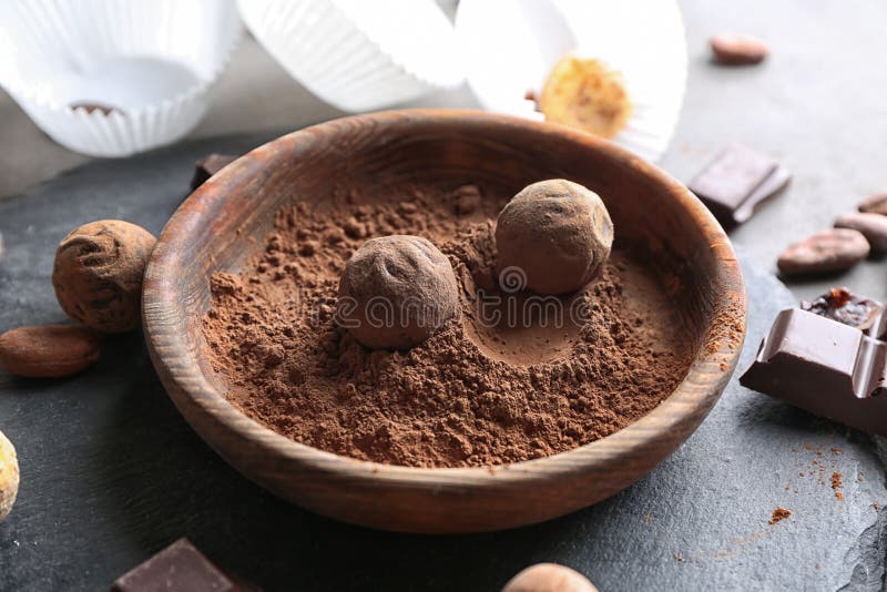 Chocolate Candies in Bowl with Cocoa Powder on Table Stock Photo ...