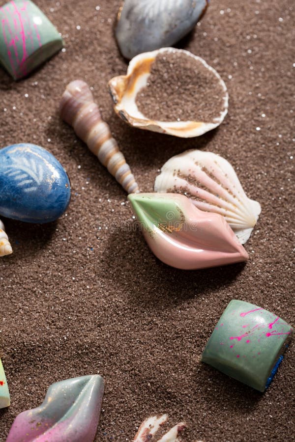 Chocolate Candies and Sea Shells on Sand Stock Photo - Image of ...
