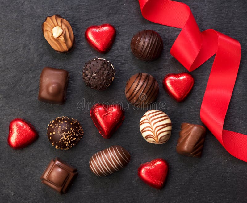 Various Chocolate Candies and a Red Ribbon Stock Photo - Image of ...