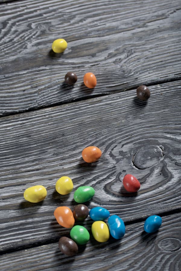 Chocolate Candy in Multi-colored Glaze. Scattered on Black Pine Boards ...