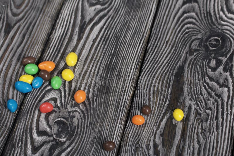 Chocolate Candy in Multi-colored Glaze. Scattered on Black Pine Boards ...