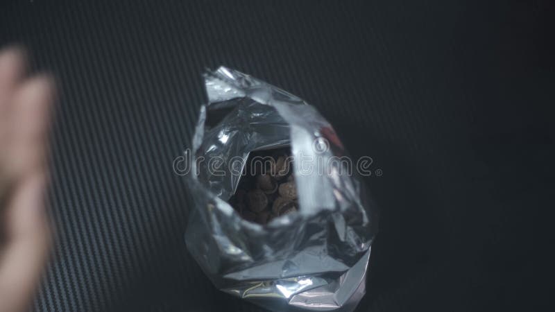 Chocolate Cereal in a Silver Package on a Black Table, Being Taken in a ...