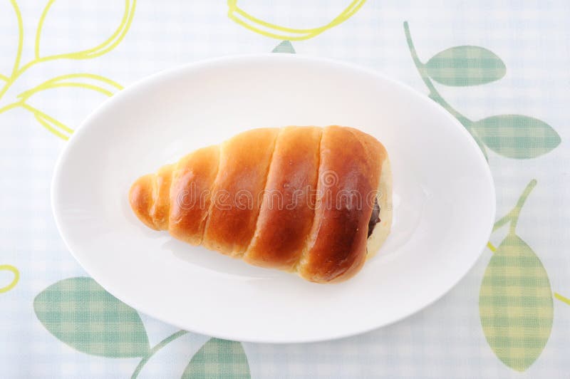 Chocolate Cornet Butter Bread Roll on a Plate on Table Cloth Stock ...