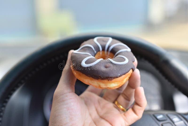 Chocolate Donuts in Hand in Car Driving Stock Photo - Image of donut ...