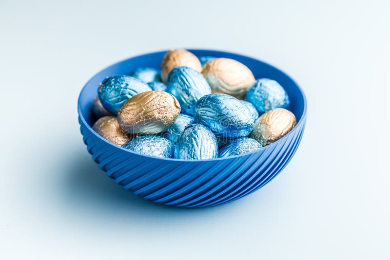 Chocolate Easter Eggs Wrapped in Multi Colored Foil on Blue Background ...