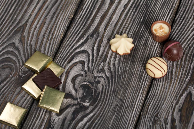 Chocolate in Foil and Chocolates. on Pine Boards Stock Image - Image of ...