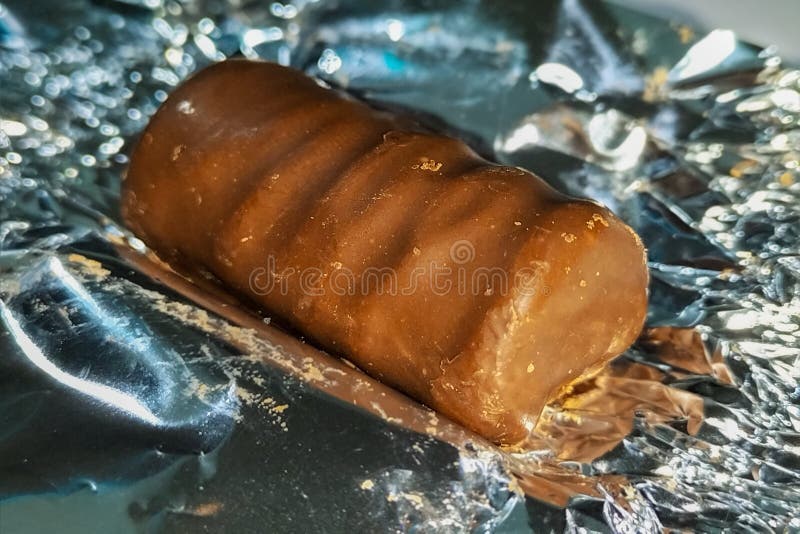 Chocolate-glazed Candy on an Open Silver Wrapper Close-up ...